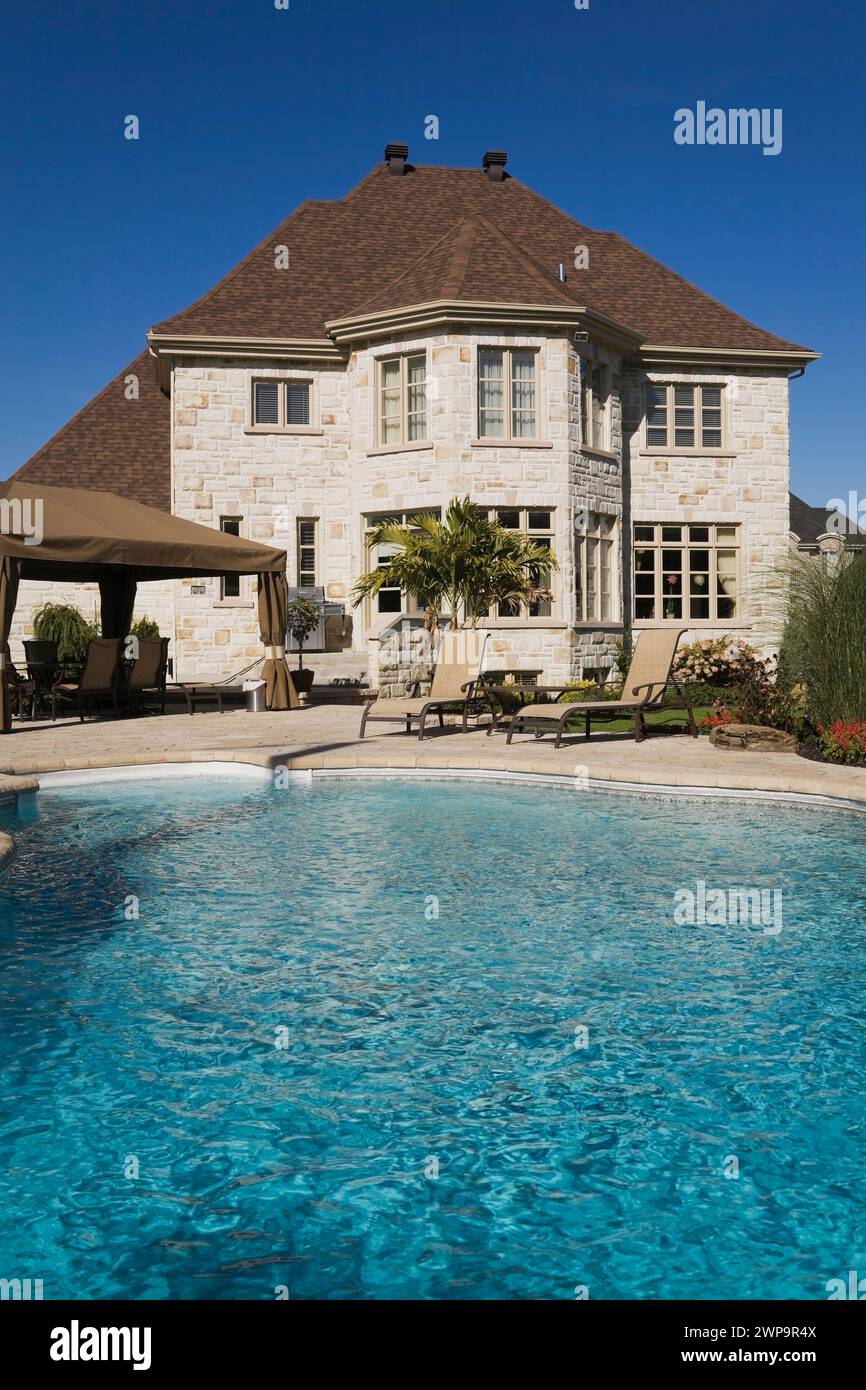 In-ground swimming pool in backyard of luxurious two story tan and ...