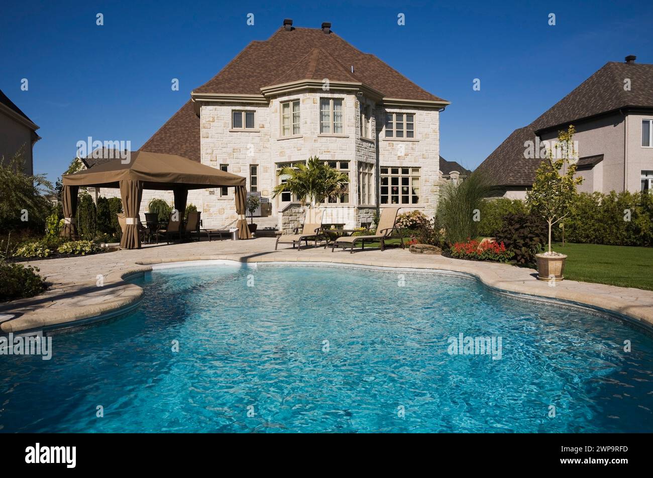 In-ground swimming pool in backyard of luxurious two story tan and ...