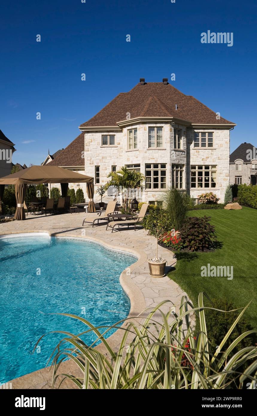 In-ground swimming pool in backyard of luxurious two story tan and ...