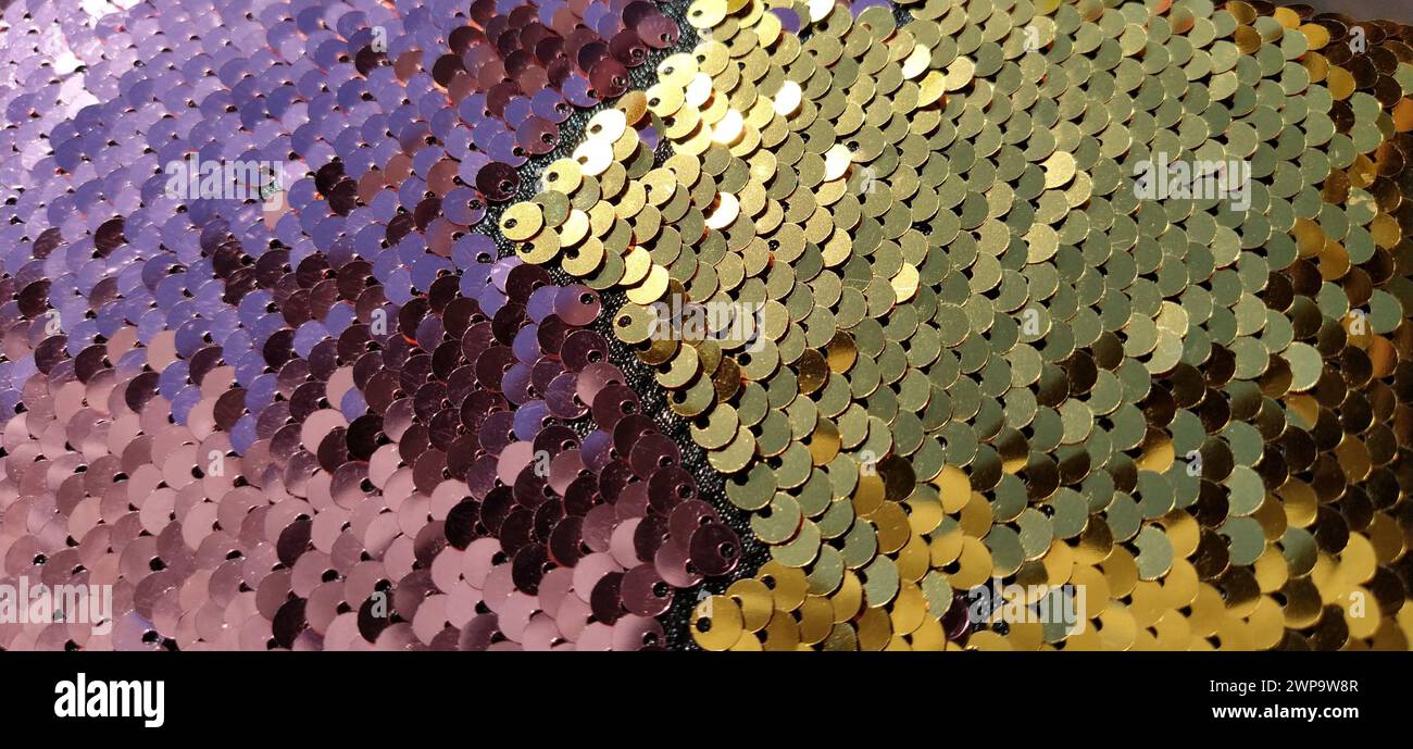 Gold, pink and multi-colored sparkles on the fabric. Rainbow blurred ...