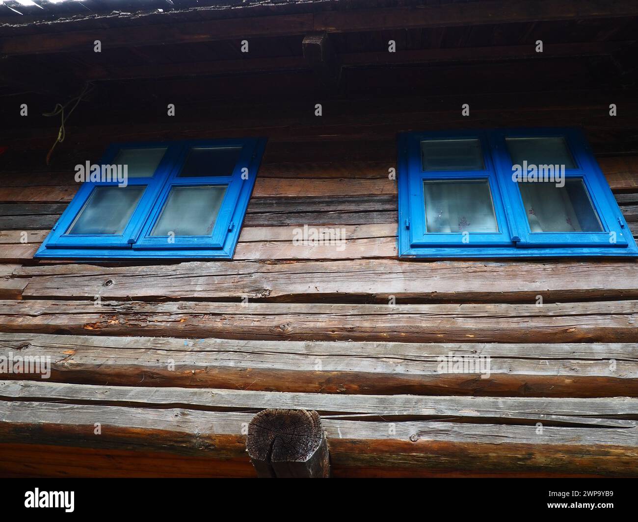 Ethno windows with a blue wooden frame. Vintage house exterior ...