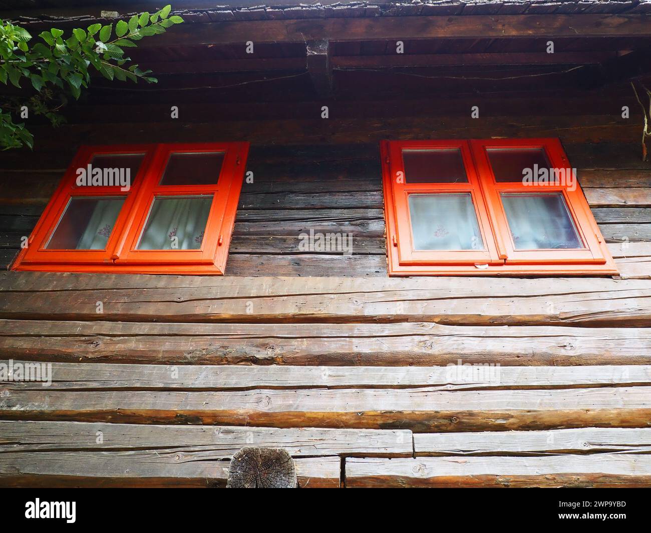 Ethno windows with a red wooden frame. Vintage house exterior ...