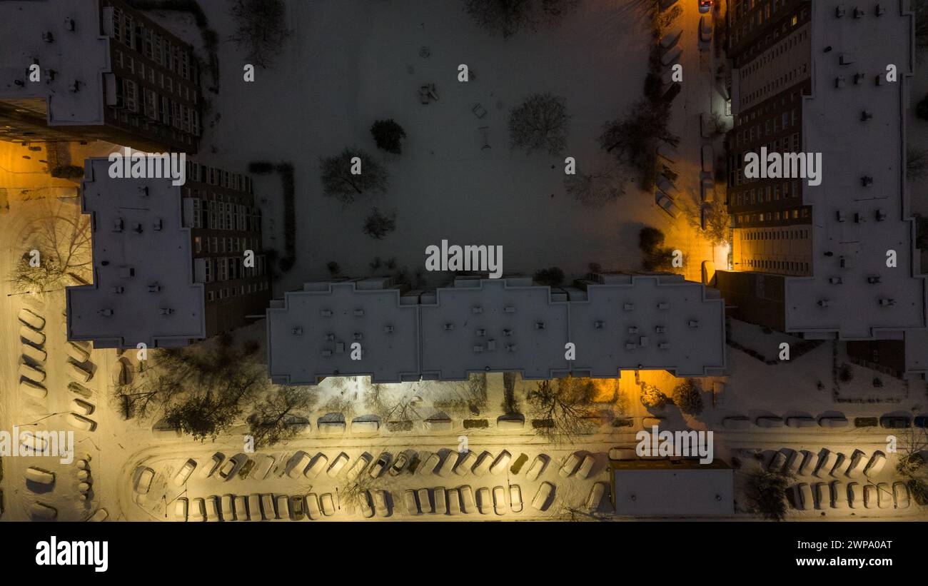 Drone photography of an apartment block and playground covered in snow ...