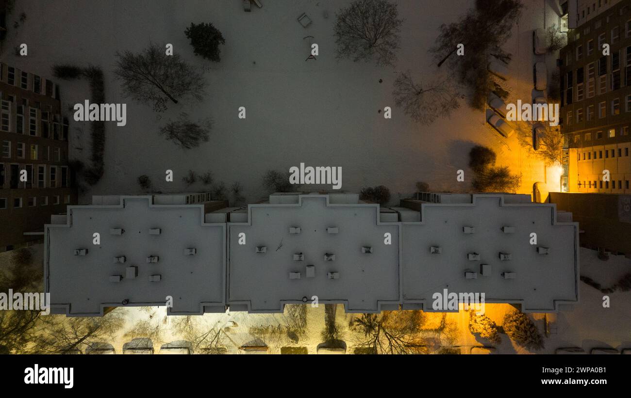 Drone photography of an apartment block and playground covered in snow ...