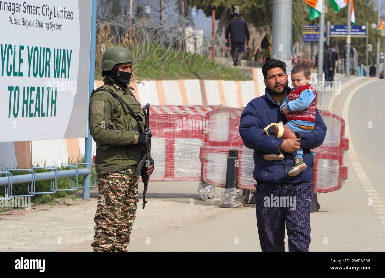 Srinagar, India. 06th Mar, 2024. Kashmiri man holds his child past ...