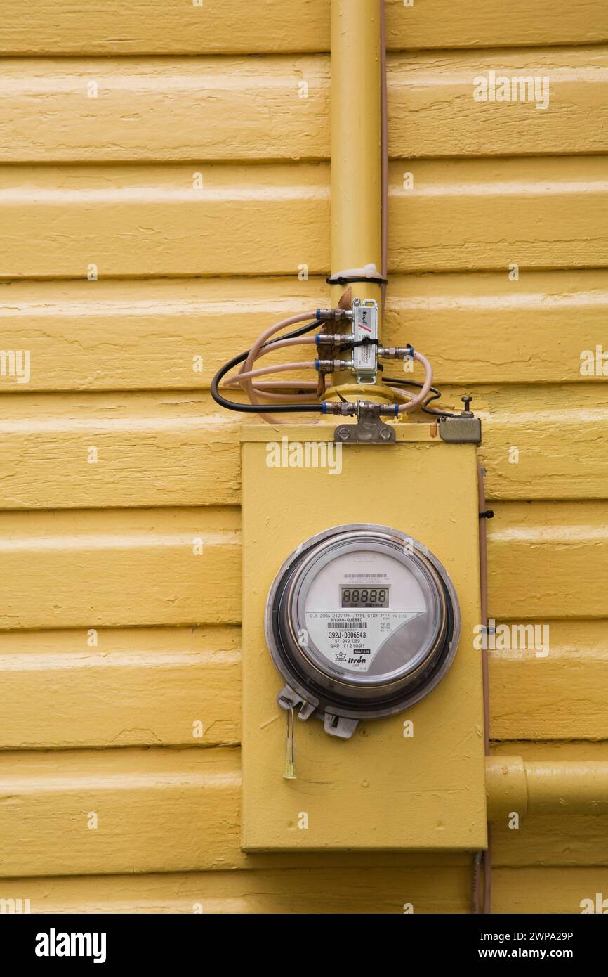 Painted yellow digital hydro electricity consumption meter on exterior ...