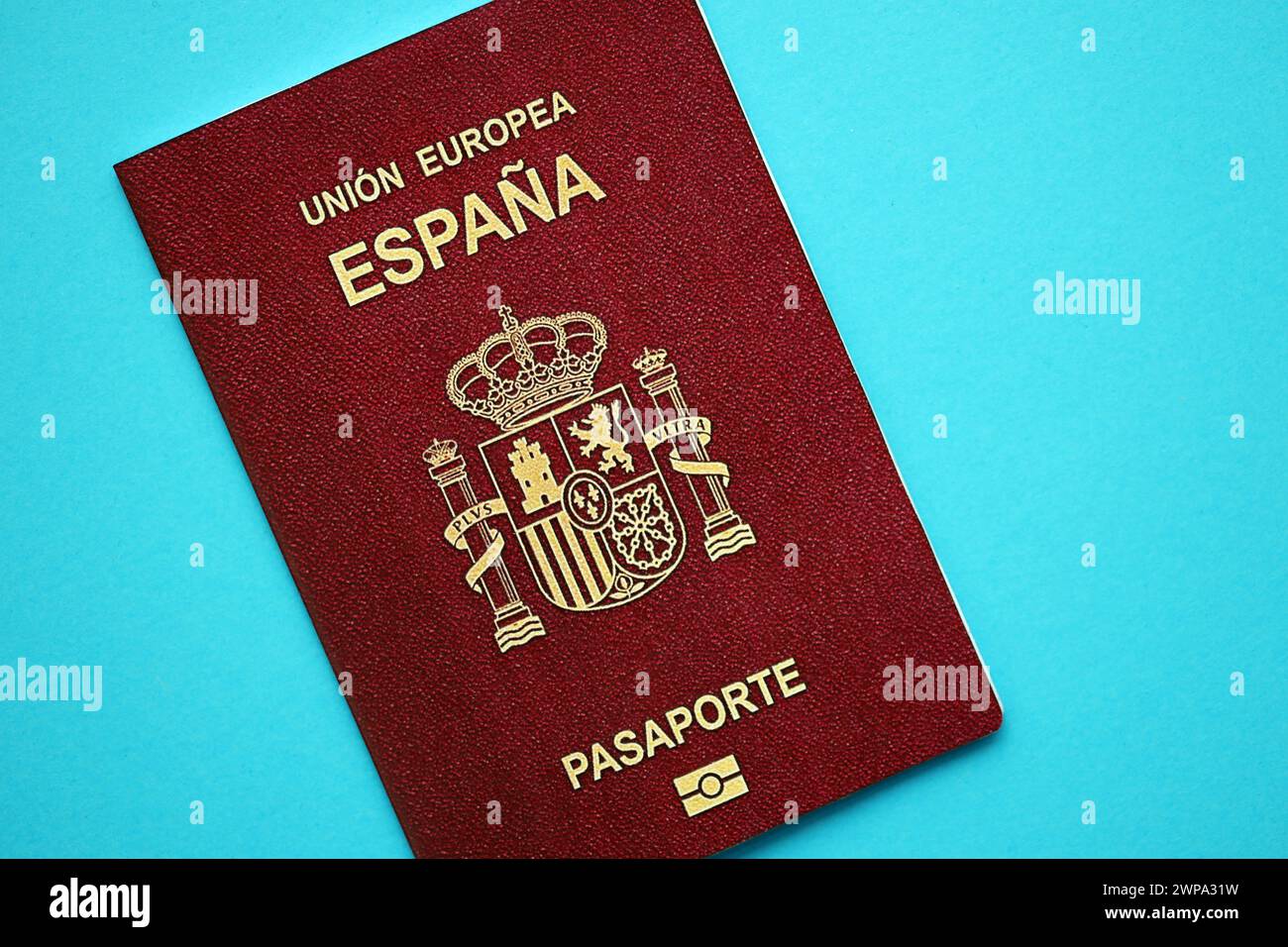 Red Spanish passport of European Union on blue background close up ...