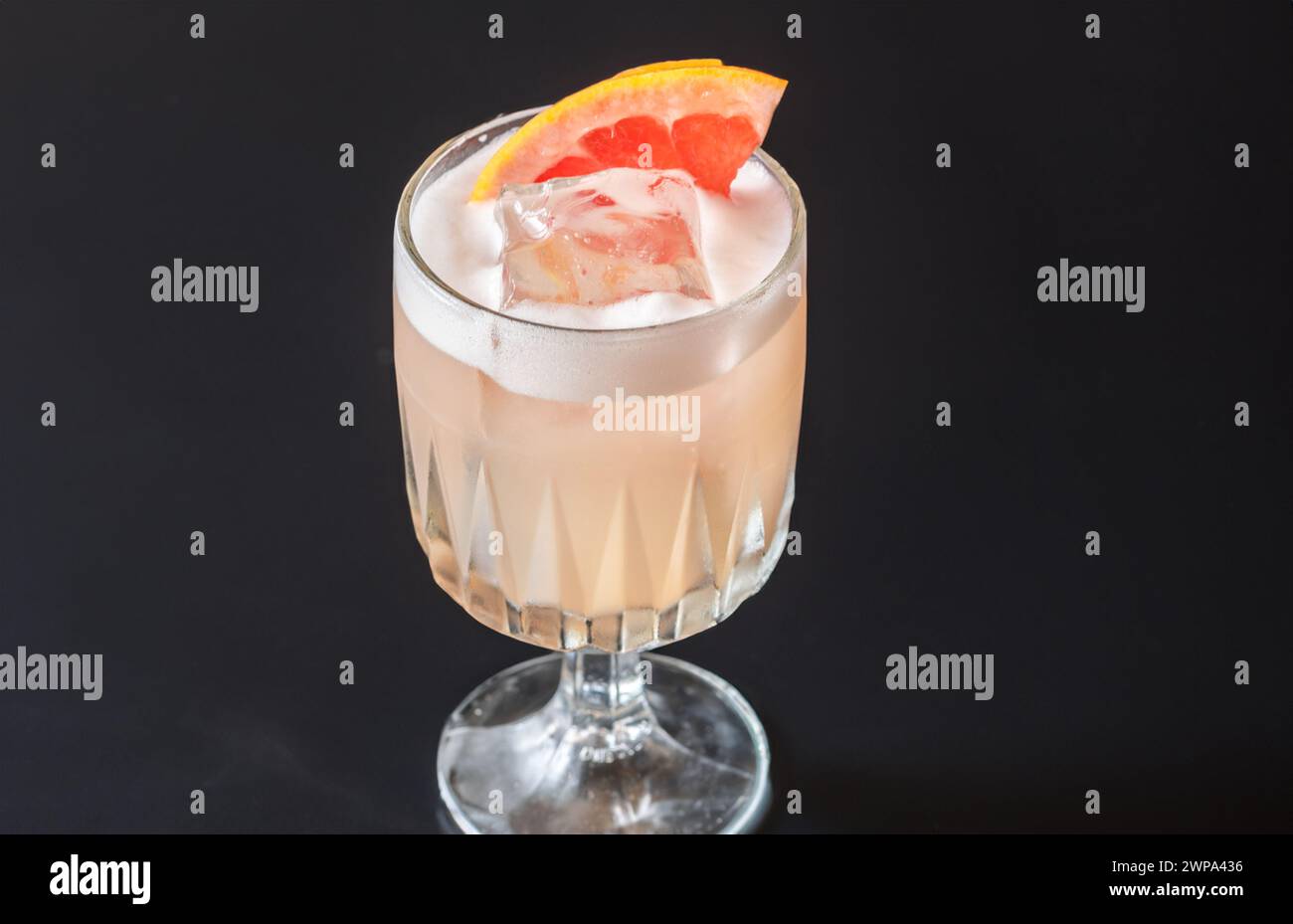 Goblet glass of Grapefruit tequila sour cocktail Stock Photo - Alamy