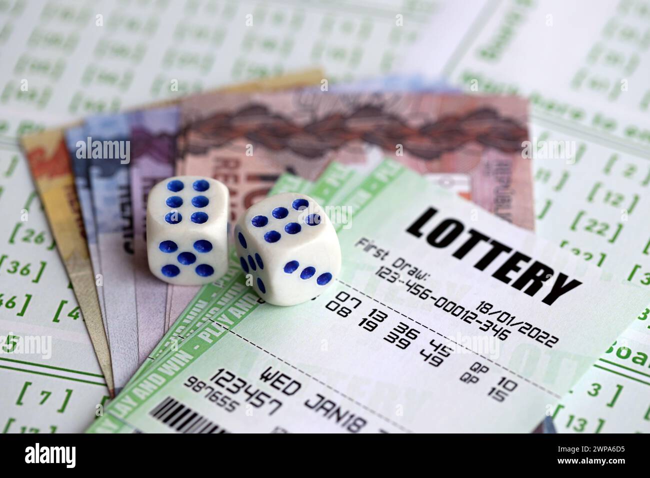 Green lottery tickets and brazilian reals money bills on blank with ...