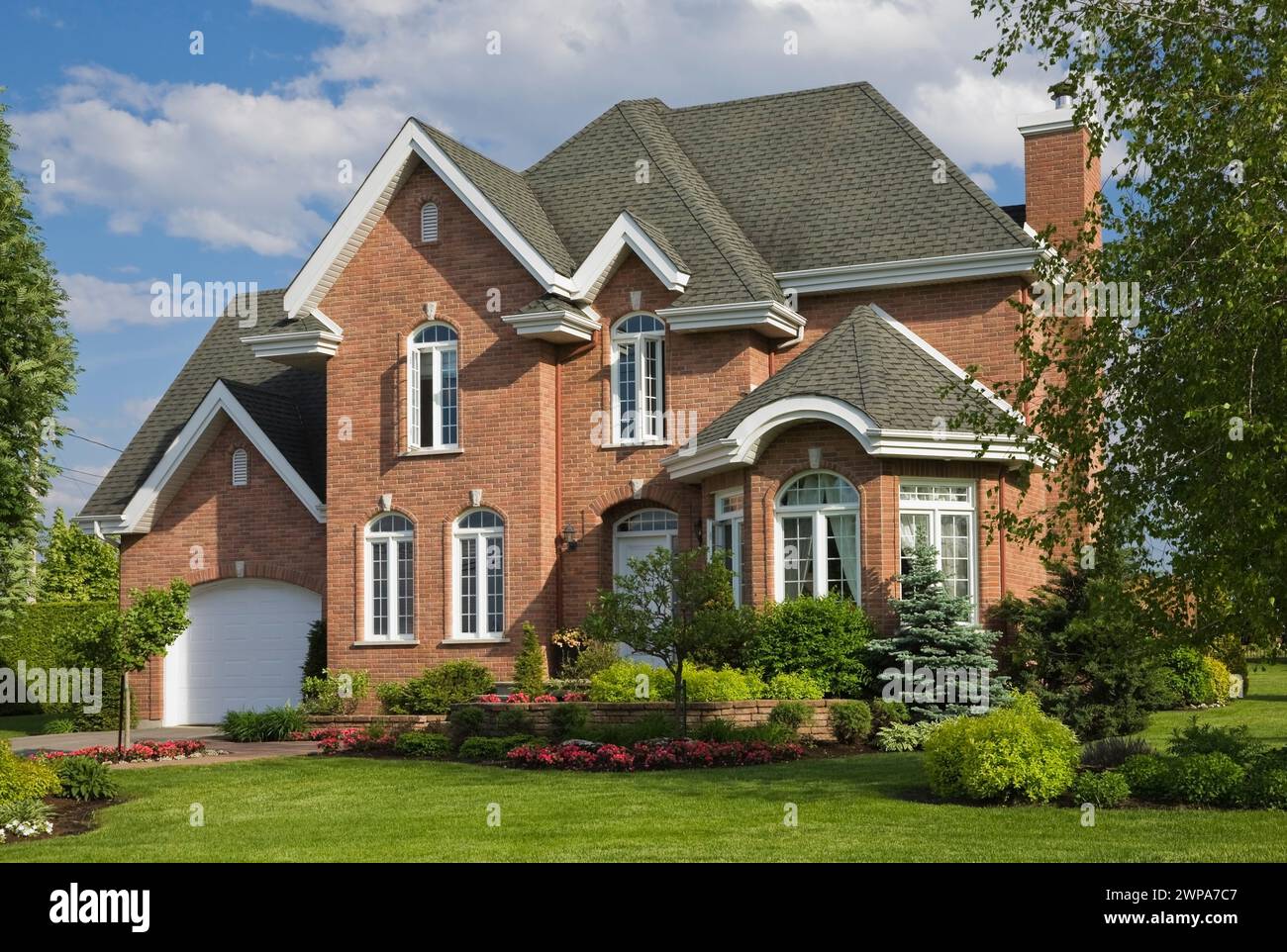 Contemporary two story red brick with white trim cladded home and ...