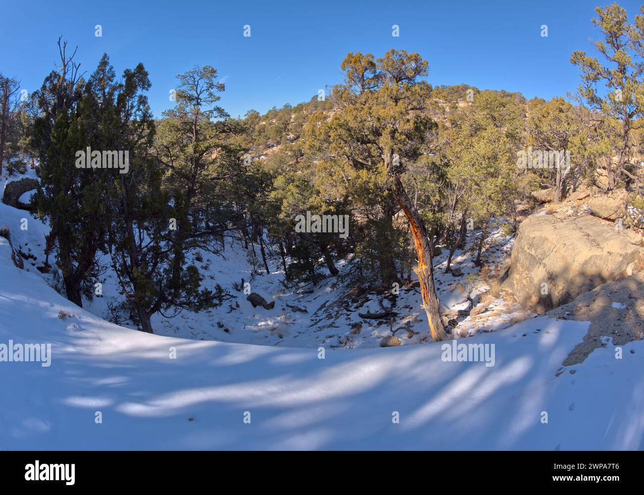 Snow covered cliff ledge overhang just above a tributary that feeds ...