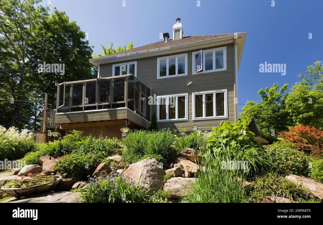 Rear view of green colored and white trim two story home with ...