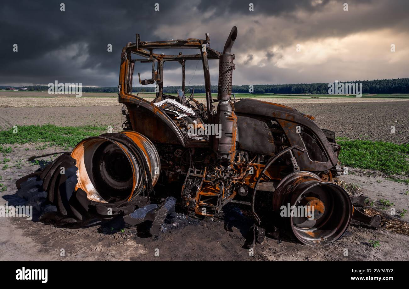 Fully destroyed burnt down tractor on a field Stock Photo - Alamy