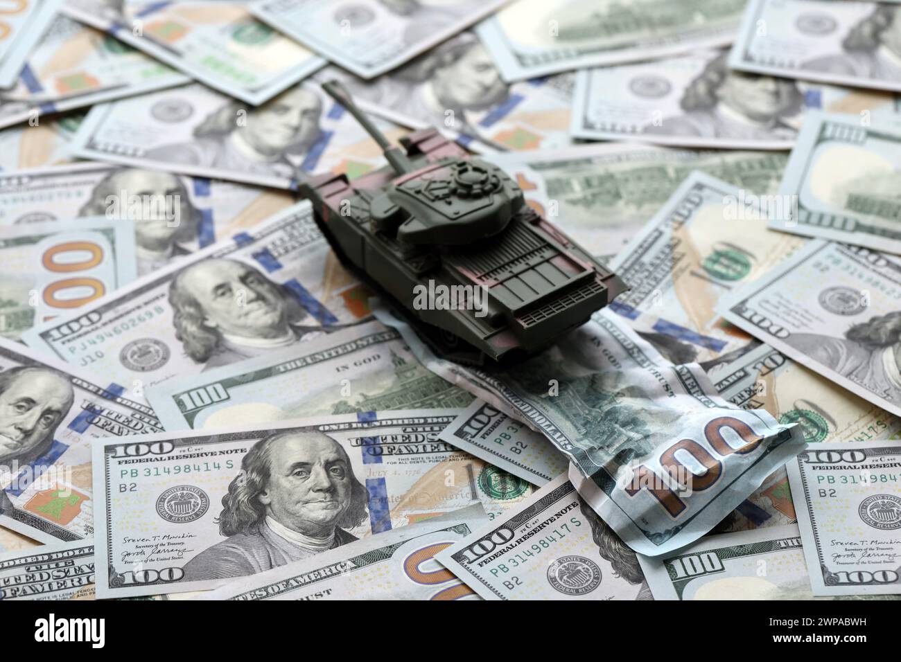 Tank on crumpled hundred dollar bills banknotes. Background of war ...