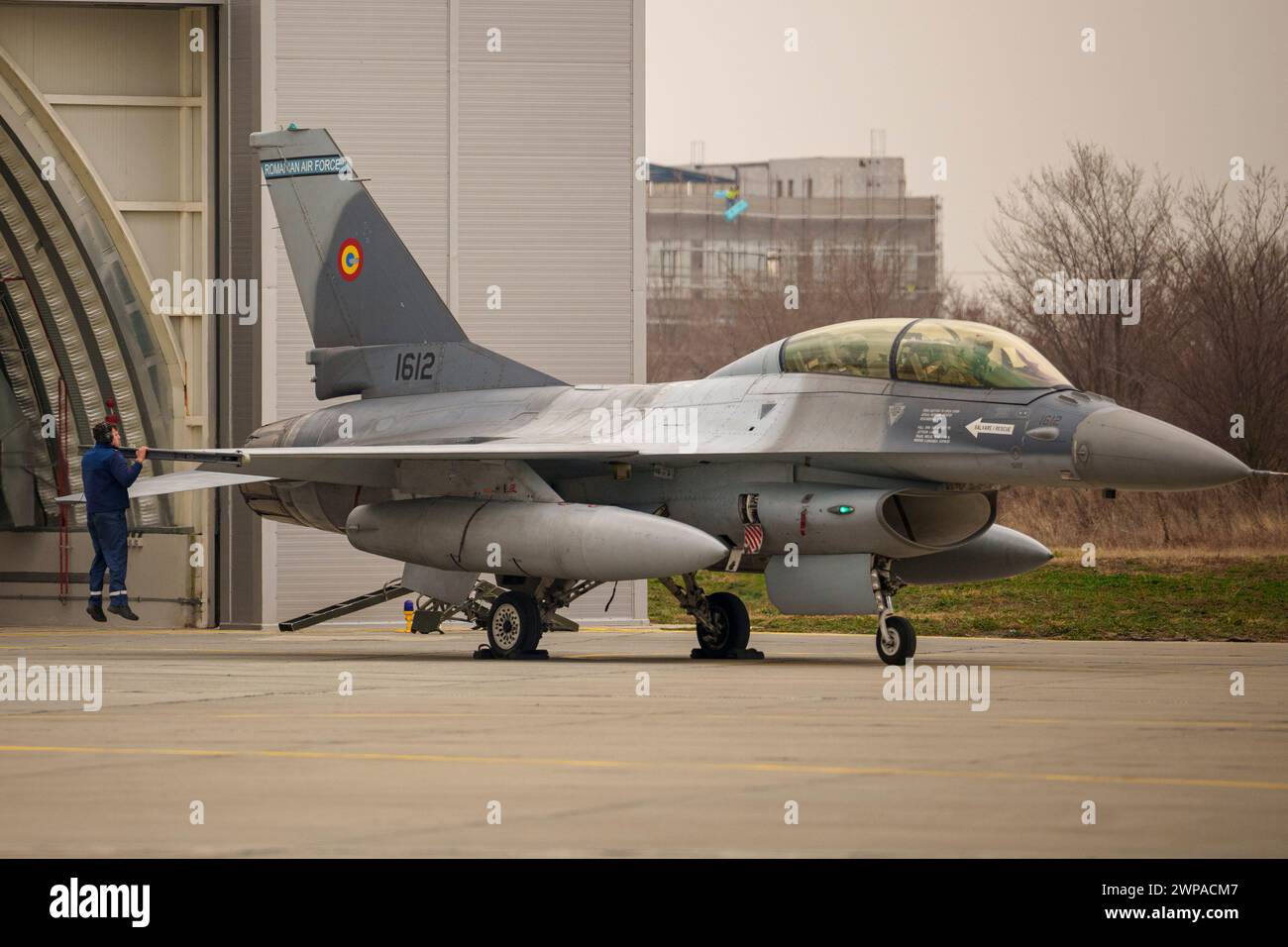 A Romanian airman makes the final checks on a F-16 military fighter jet ...