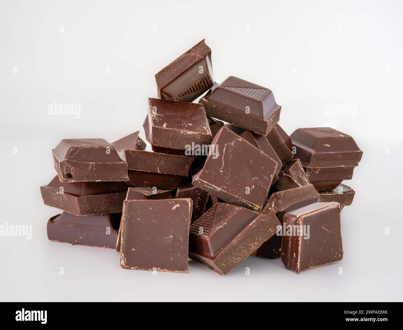 cubes squares of dark chocolate in a heap isolated on a white ...