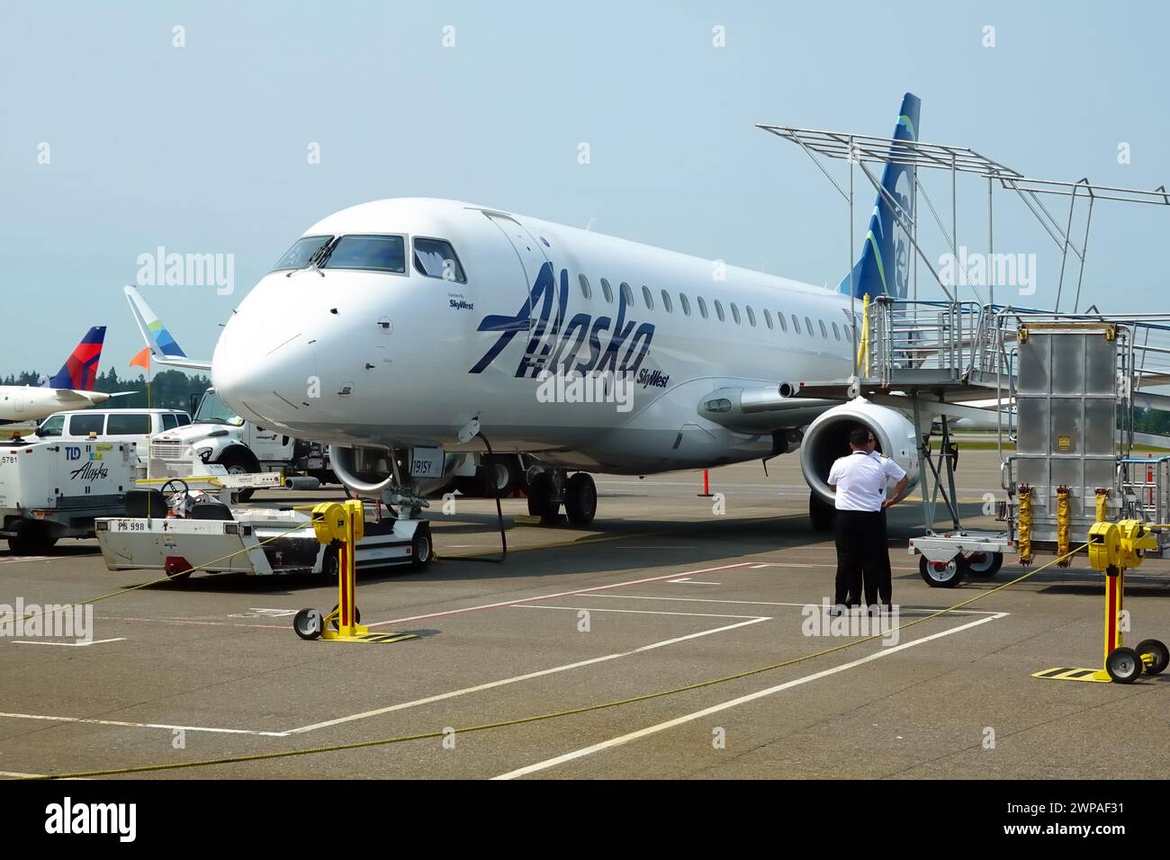 An Alaska SkyWest aircraft sits on the asphalt being readied for flight ...