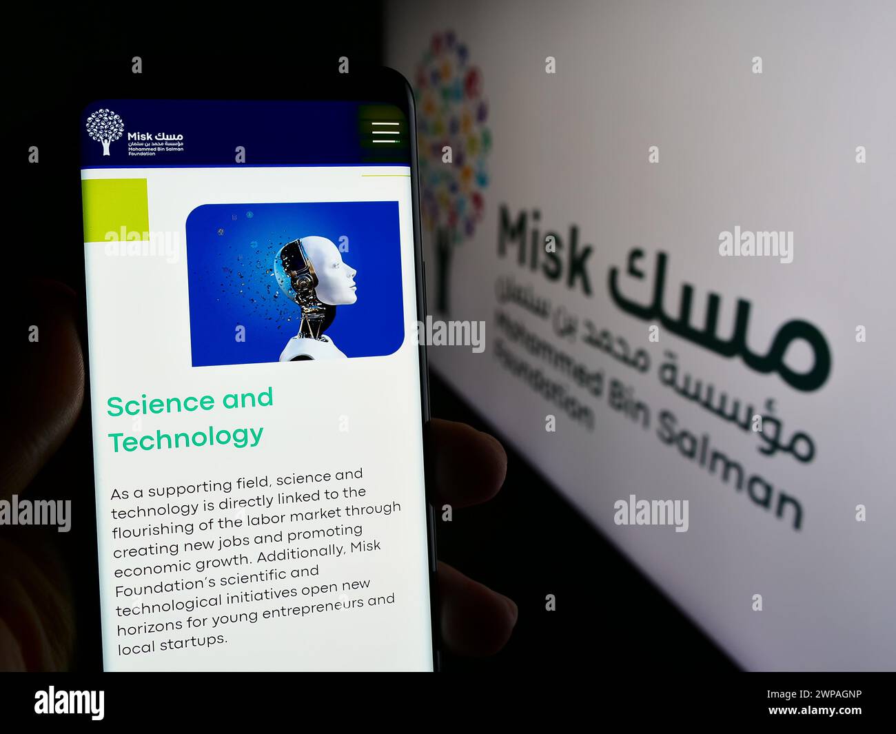 Person holding smartphone with web page of Saudi Arabian organisation ...