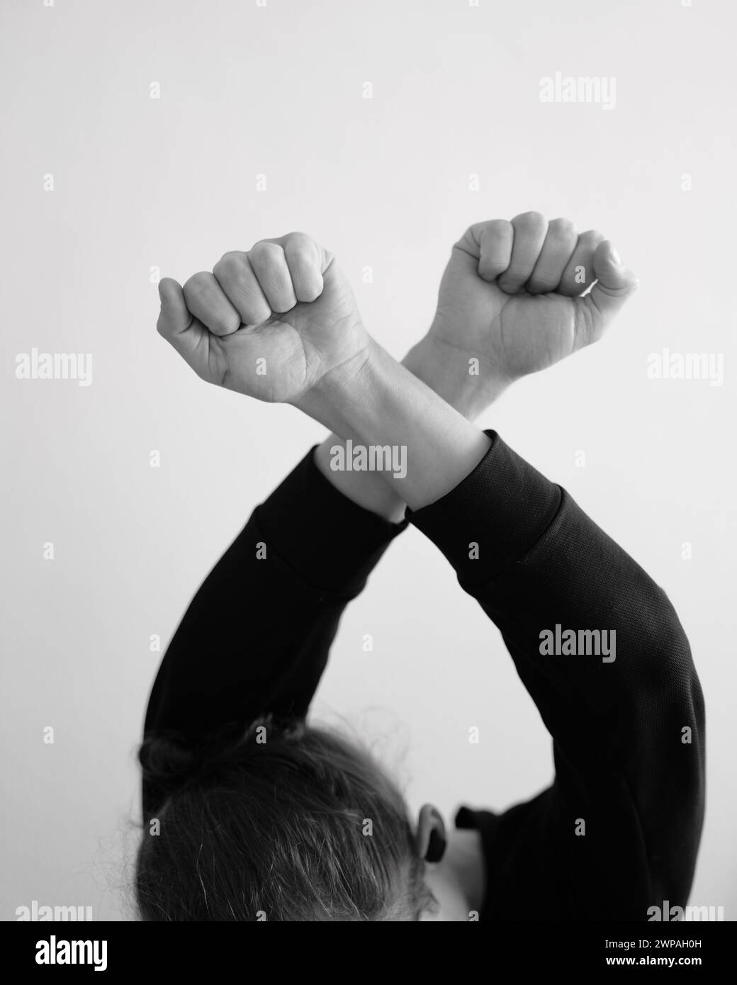 A person holding crossed hands above the head. X symbol using the hands ...