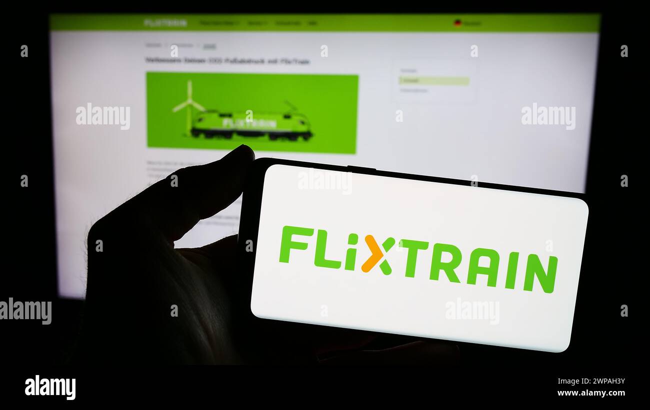 Person holding smartphone with logo of German long-distance railway ...