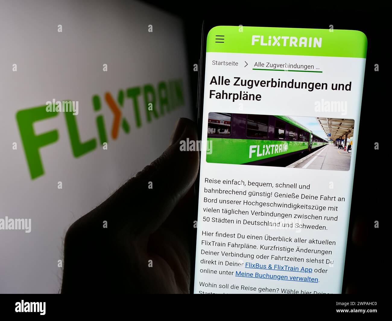 Person holding cellphone with webpage of German long-distance railway ...