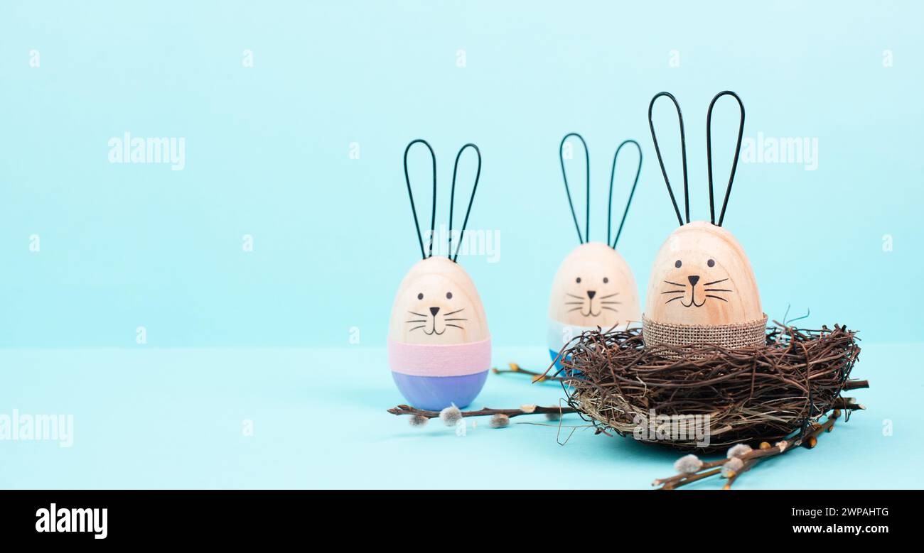 Easter bunny or rabbit sitting in a bird nest, willow branches, wooden ...