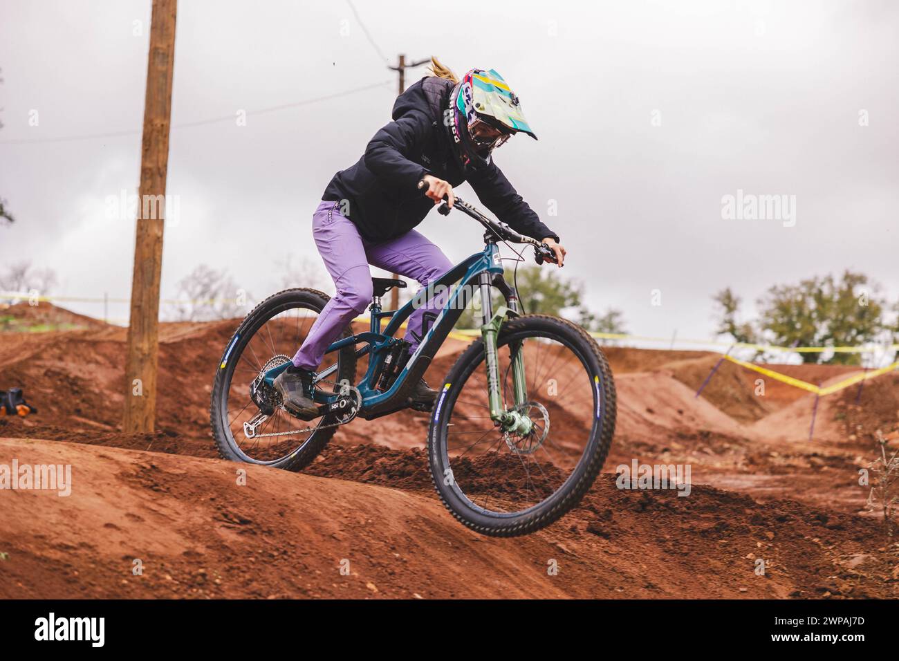 A woman riding her mountain bike on a muddy trail Stock Photo - Alamy