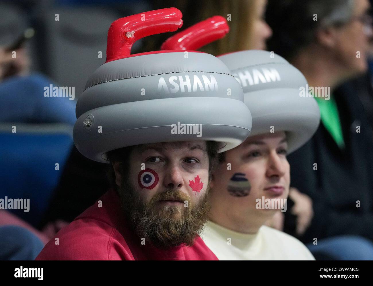 Spectators wear inflatable curling rocks while watching the morning ...