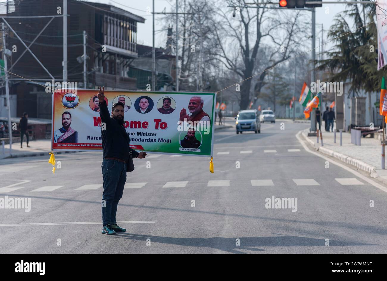 A man flashes a victory sign as he erects Bharatiya Janata Party (BJP ...