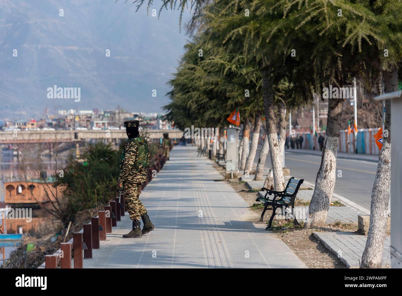 Indian paramilitary troopers patrol along a street adorned with Indian ...