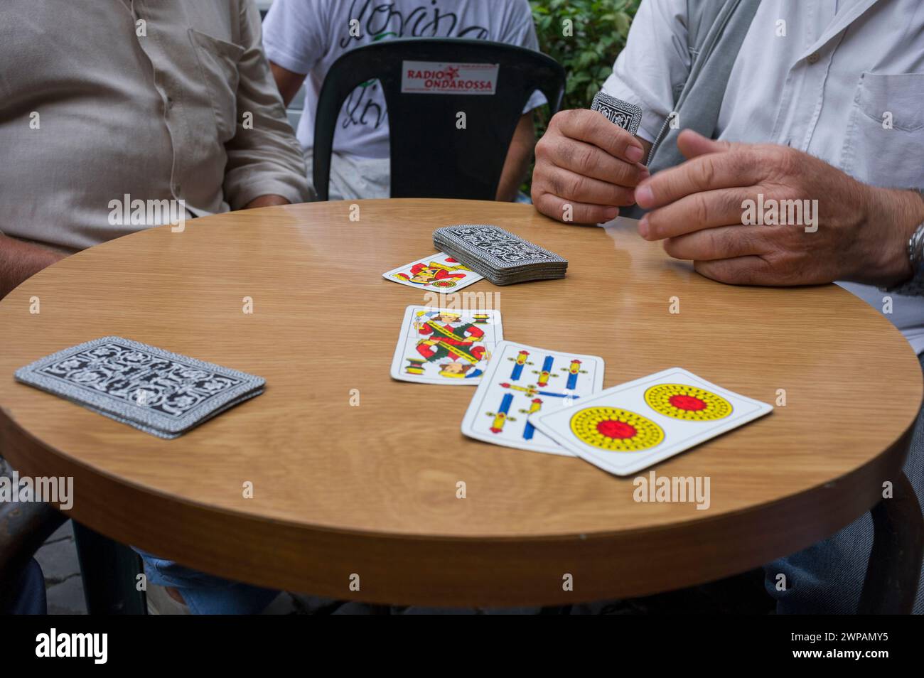 Joueurs de cartes a la table d'un cafe jouant à la Scopa ou à la ...