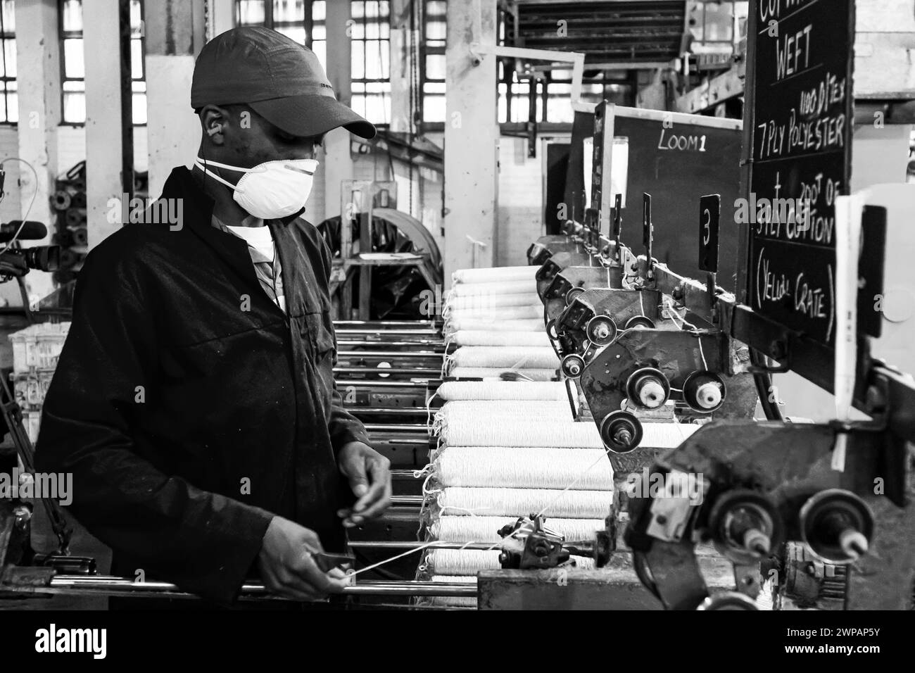 A worker donning a protective face mask in preparation for work Stock ...