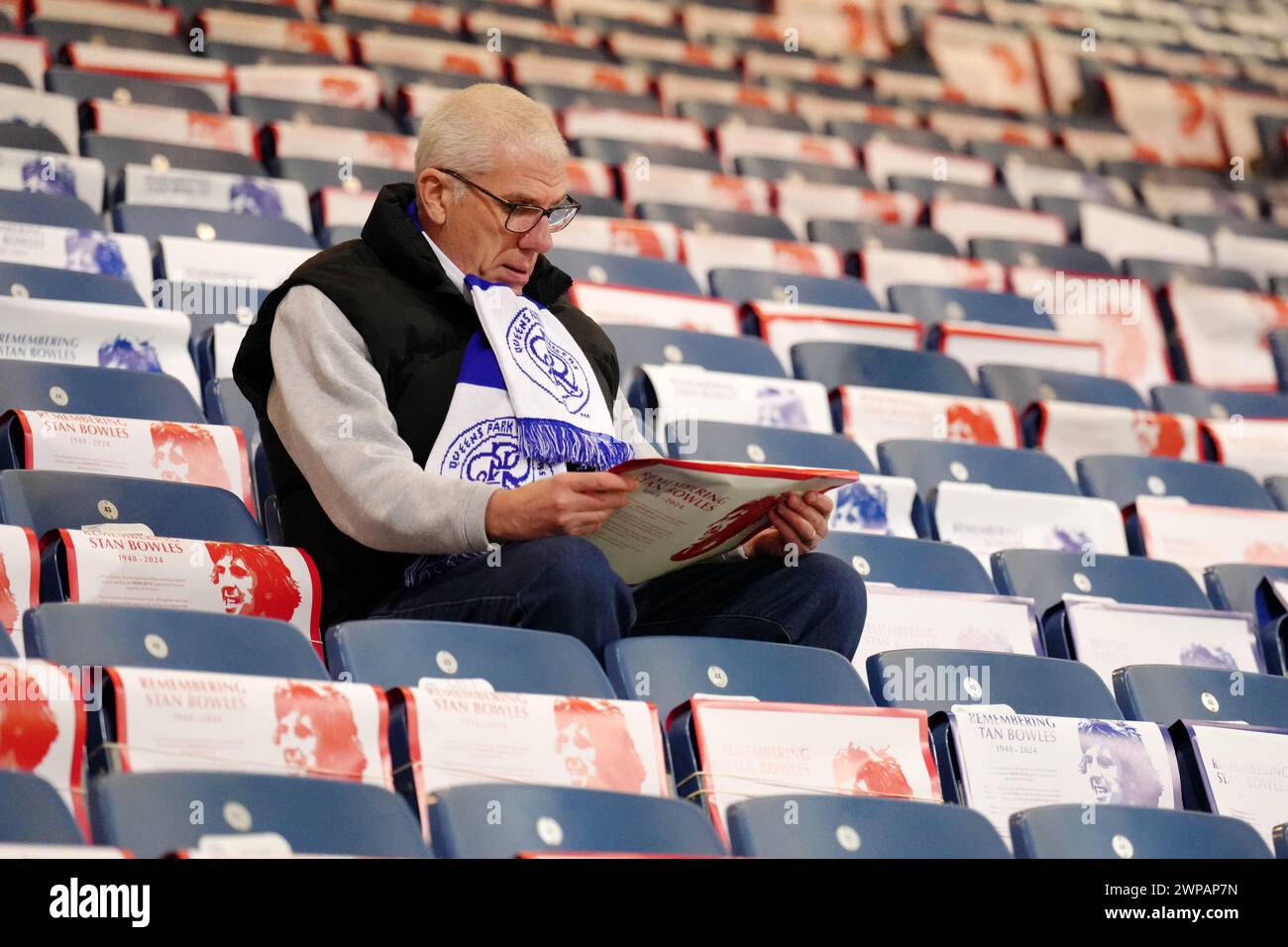 A Queens Park Rangers fan reads a display card in memory of Stan Bowles ...