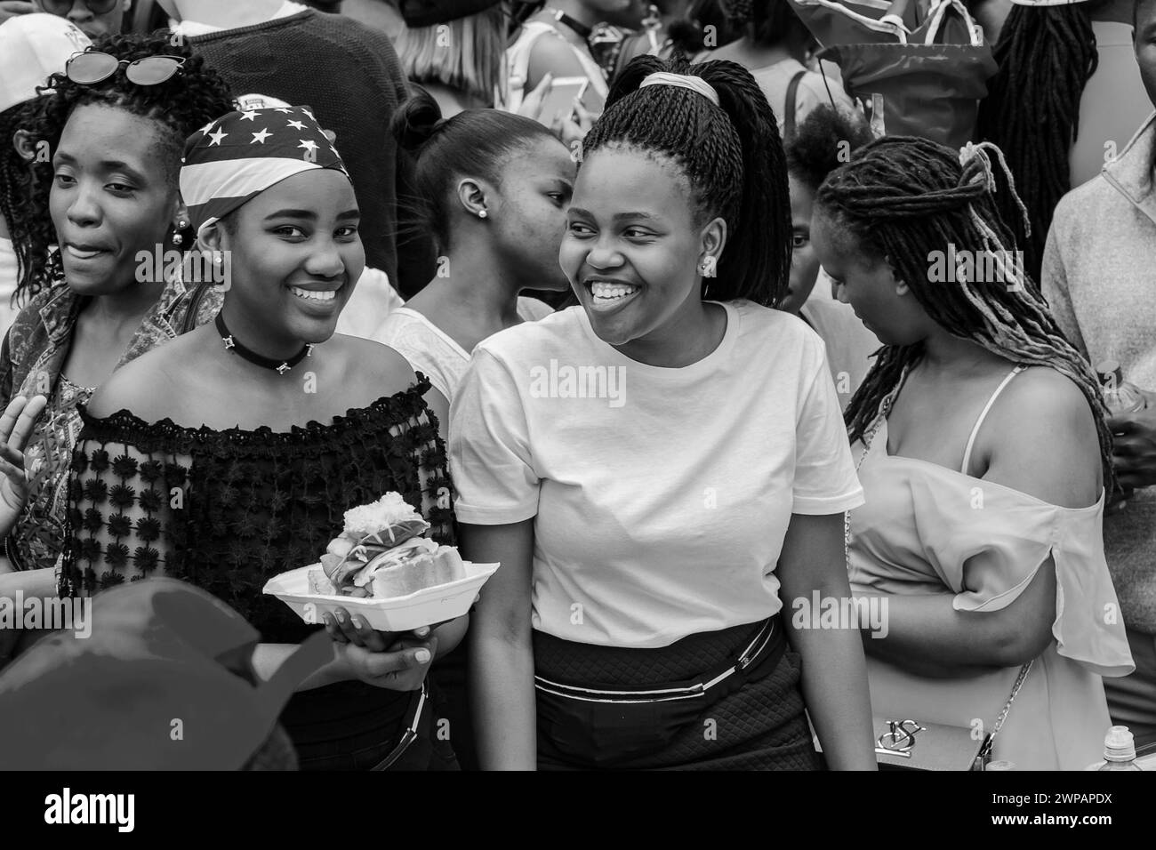 A diverse group of young individuals wearing hats standing together ...