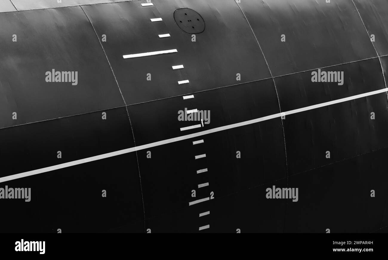 Black military submarine hull with white waterline and draft scale ...