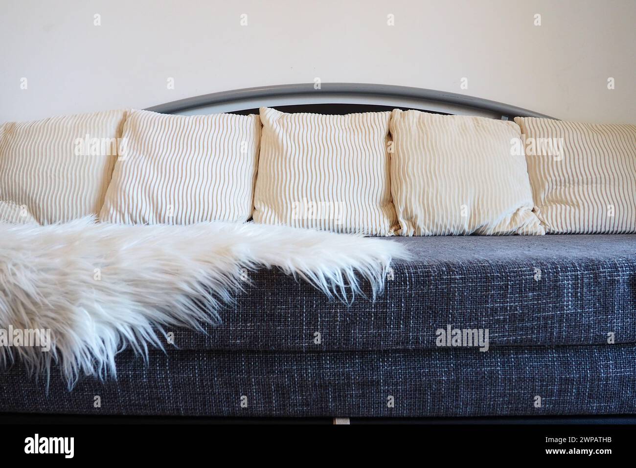 Gray sofa with rough upholstery fabric boucle and white decorative ...