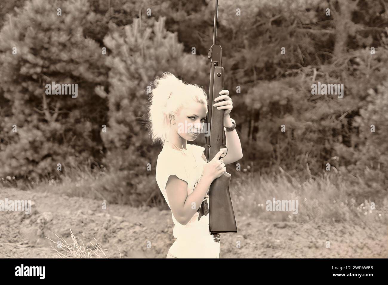 A young beautiful blonde girl shoots from a rifle. Air rifle shooting ...