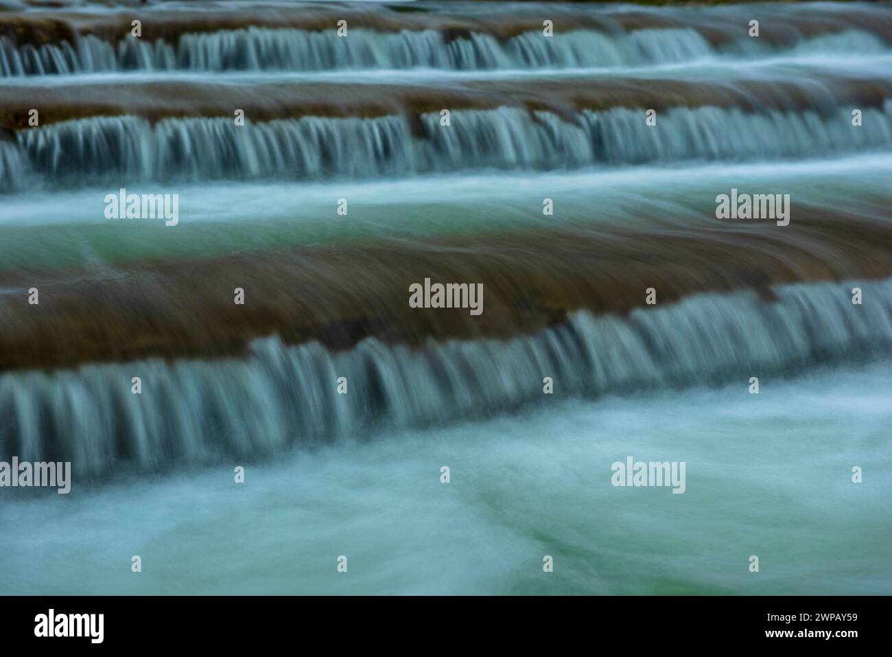 water flows down the waterfall cascades, water is blurry, wavy cascades ...