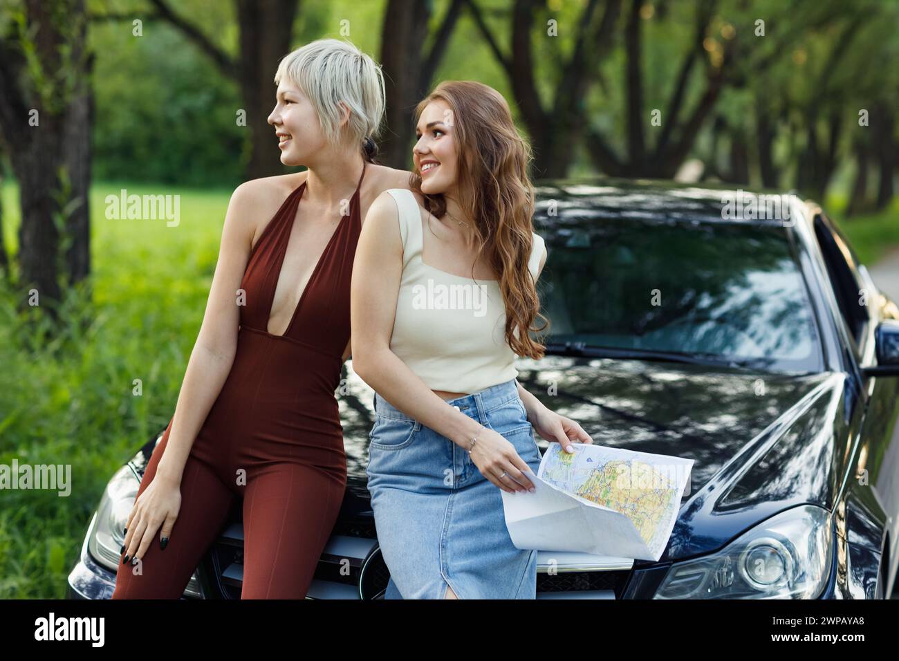 Two woman drivers at car smiling. Cute young happy female driving car ...