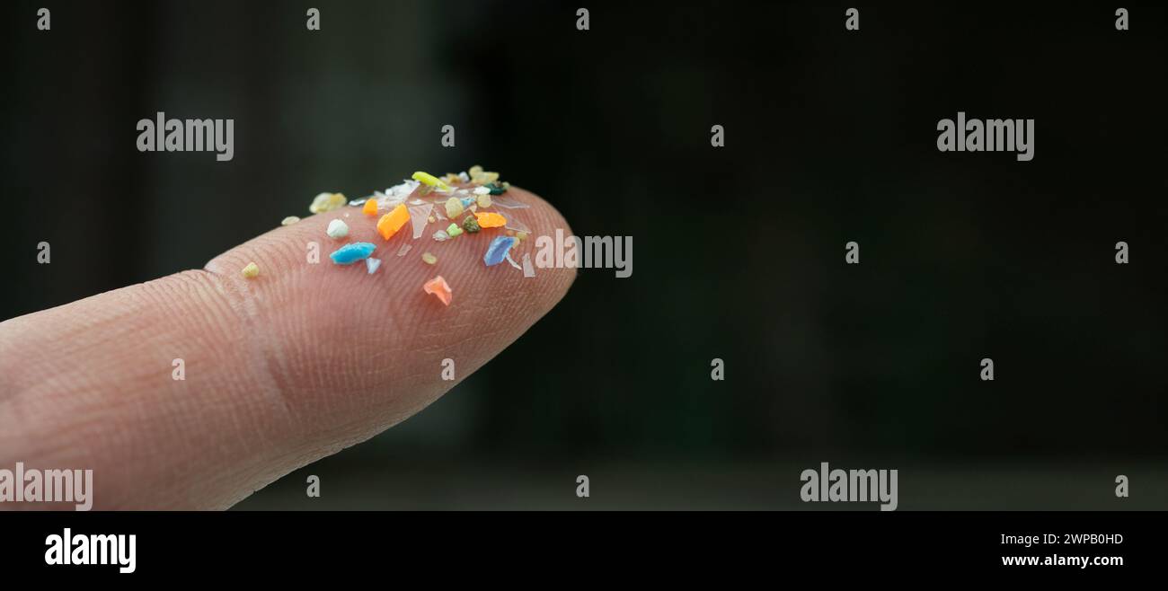 Macro shot of microplastics on human finger. Concept of plastic ...
