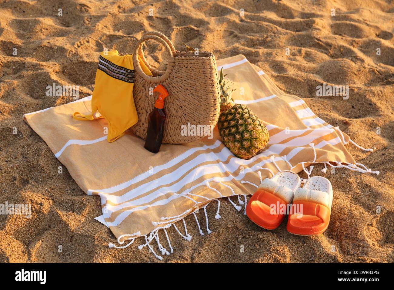 Stylish beach bag, flip-flops, pineapple, sunscreen spray, swimsuit and ...