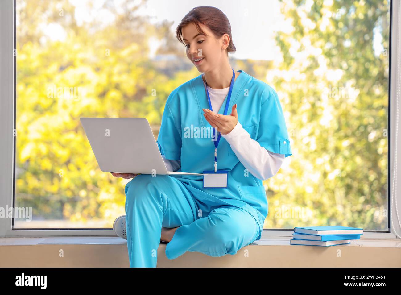 Female medical intern with laptop in hall Stock Photo - Alamy