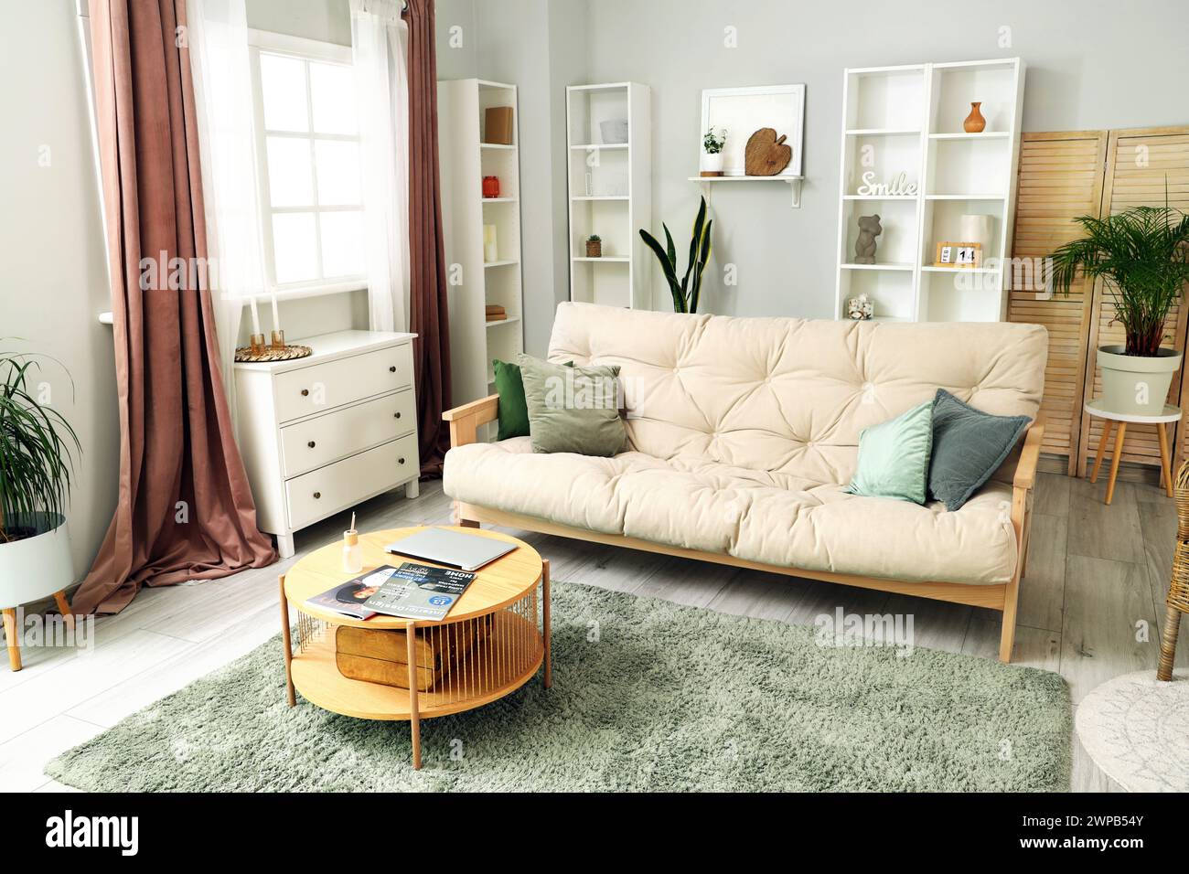 Interior of cozy living room with sofa, table and drawers Stock Photo ...