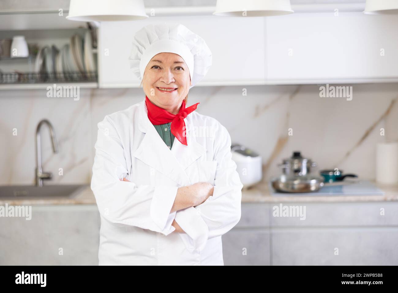 Portrait of a mature female chef posing in a kitchen Stock Photo - Alamy