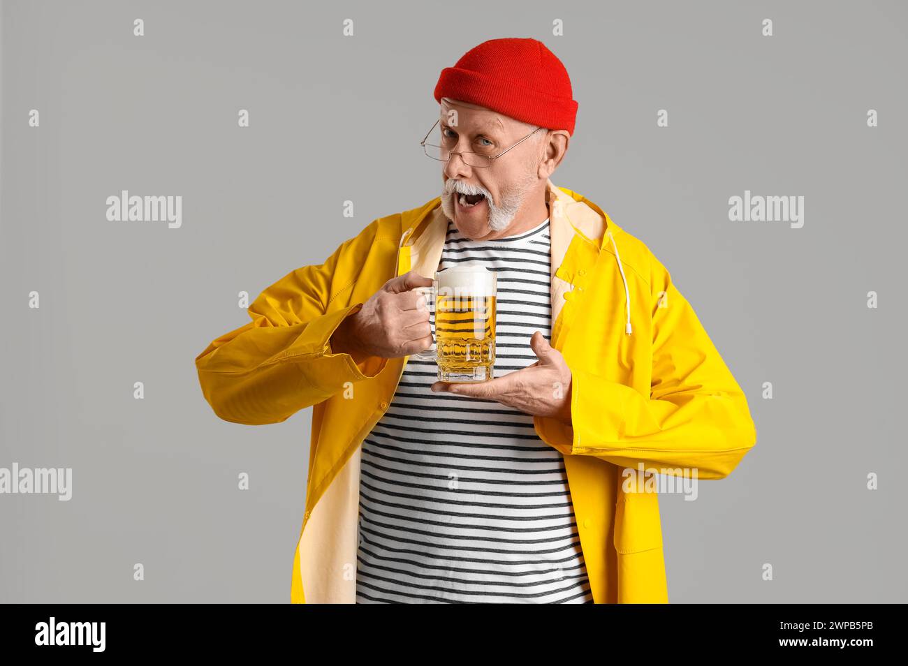 Mature sailor with beer on grey background Stock Photo - Alamy