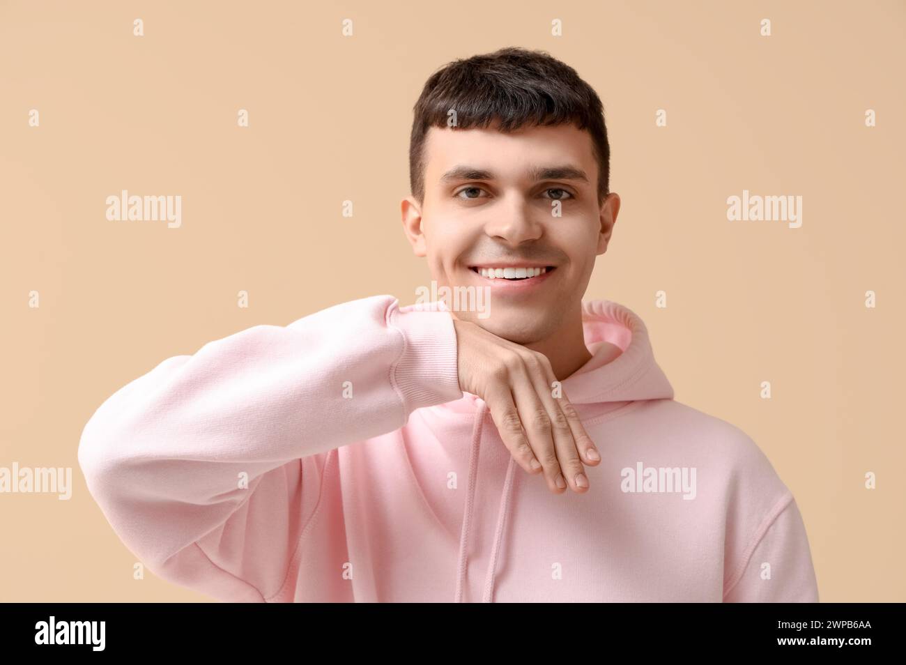 Young deaf mute man using sign language on beige background Stock Photo ...