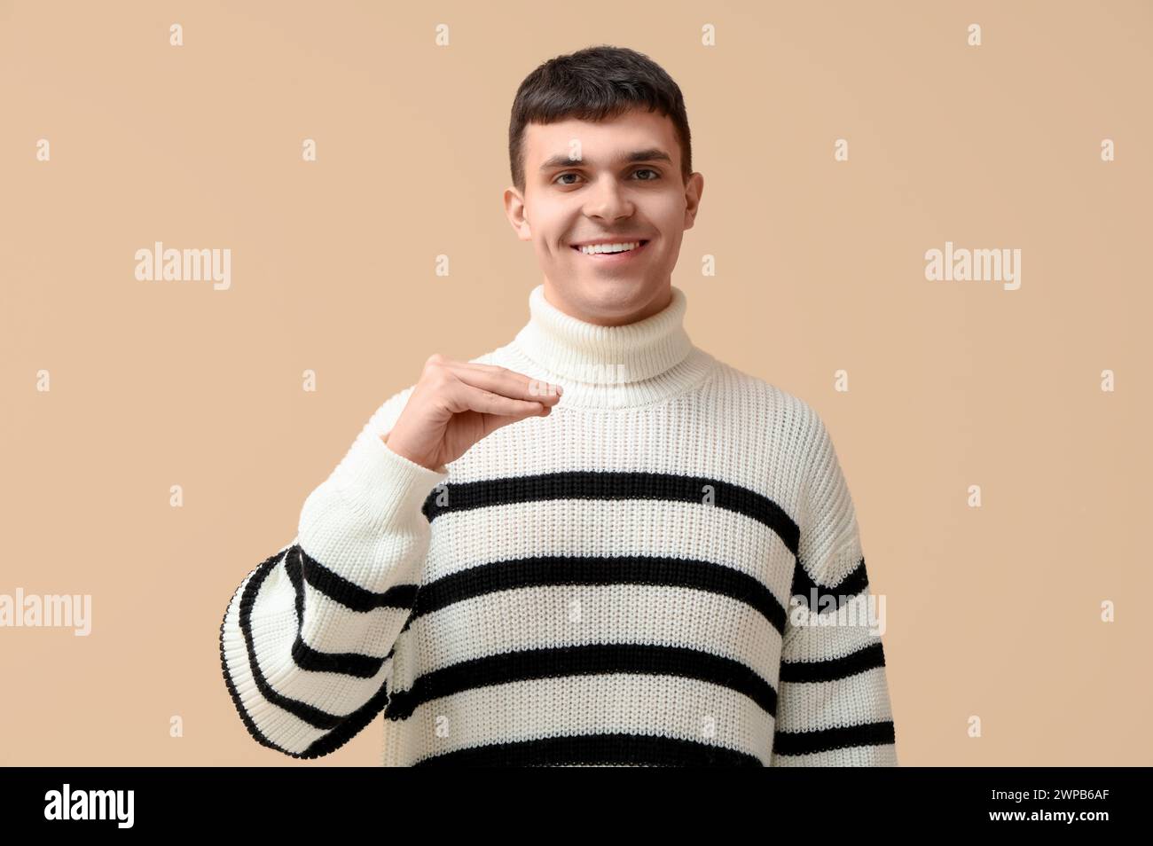 Young deaf mute man using sign language on beige background Stock Photo ...