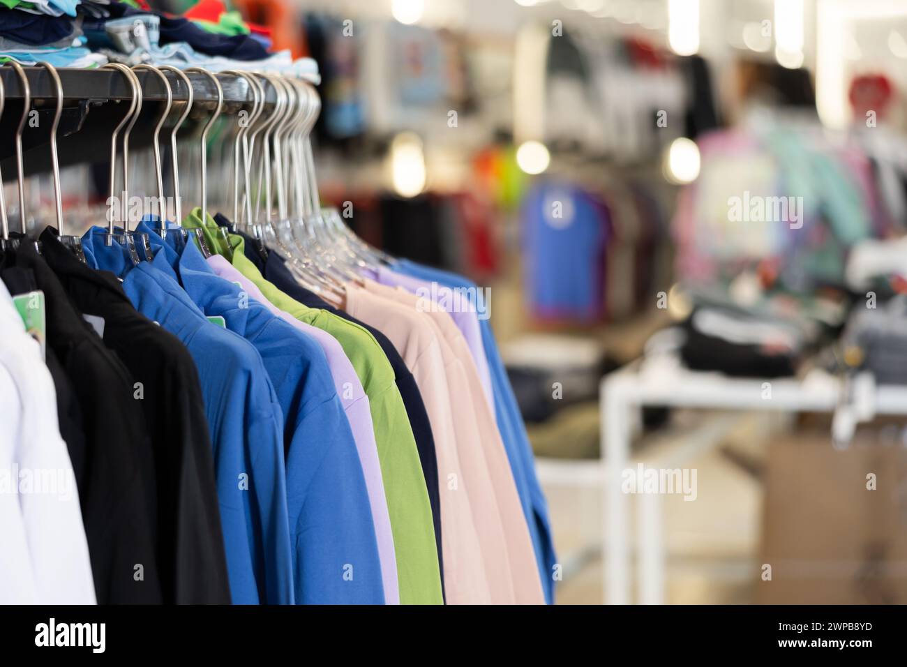 Colorful basic shirts hanging on stand in big clothing store Stock ...