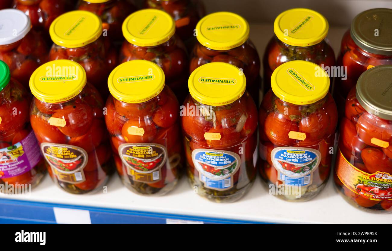 Russian goods store shelves have glass jar with canned pickled tomatoes ...