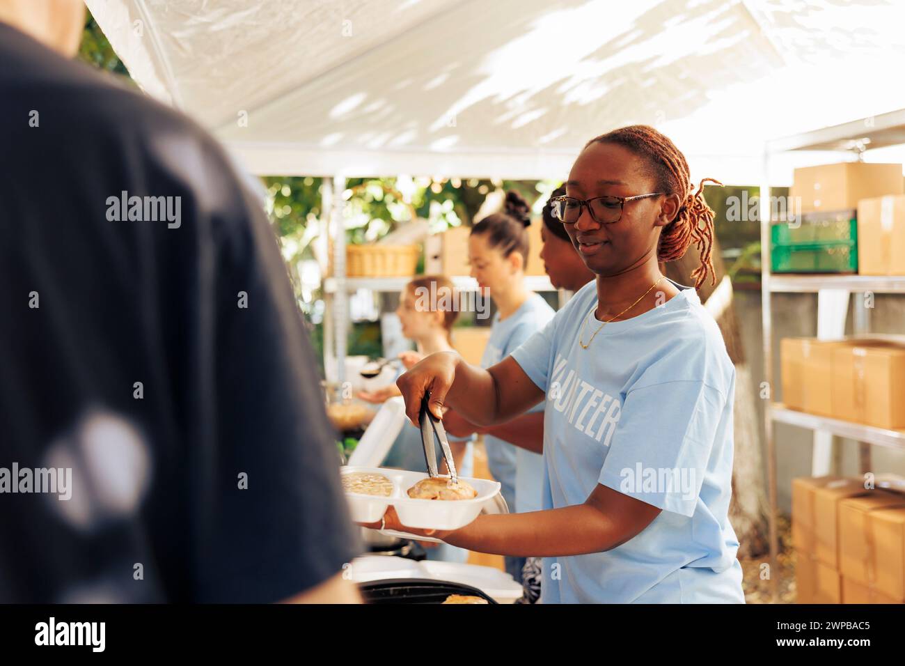 African american woman serving free food to the poor, needy individual ...